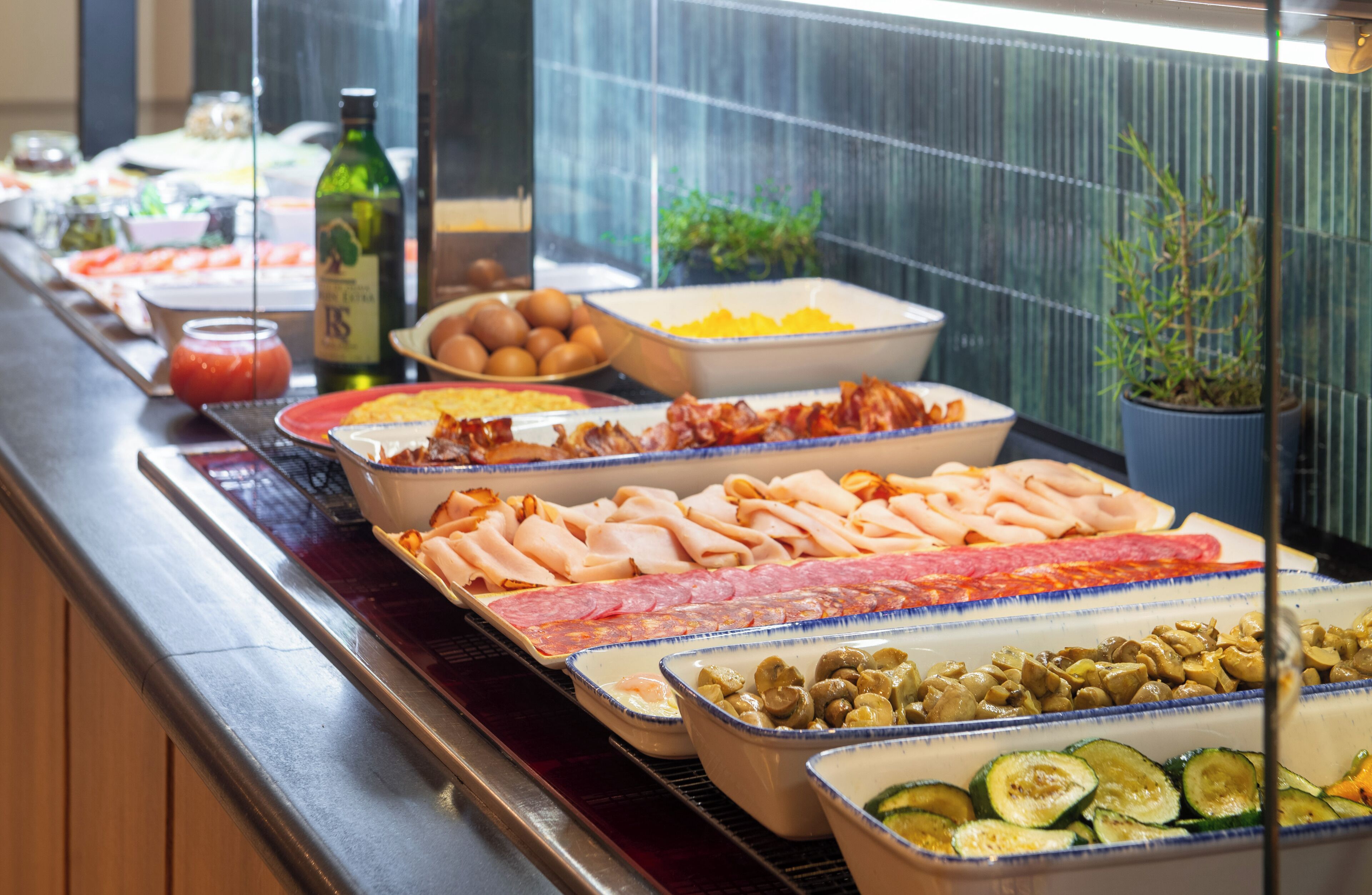 Buffet com diversos alimentos, incluindo carnes, legumes e ovos.