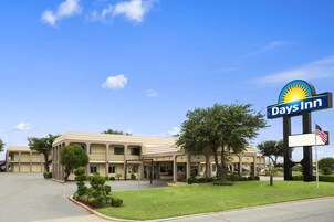 Um Days Inn com uma placa grande, várias varandas e um gramado bem cuidado.