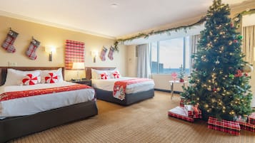 Quarto de hotel com duas camas, decorações de Natal, árvore de Natal e vista para a cidade.