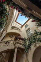 Pátio interior com arcos, colunas e vista do céu através de um claraboia.