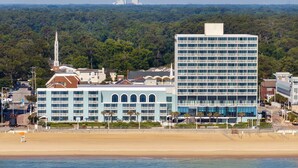 Hotel à beira-mar com um edifício moderno e uma igreja ao fundo.