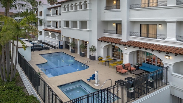 Um hotel com piscina, área de estar externa e varandas.