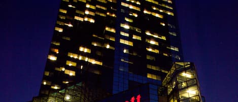 Edifício de um hotel Marriott à noite, com janelas iluminadas e uma placa bem visível.