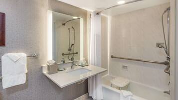Uma casa de banho moderna com lavatório, espelho e chuveiro.