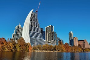 Um horizonte urbano moderno com um edifício curvo imponente e várias outras estruturas altas.