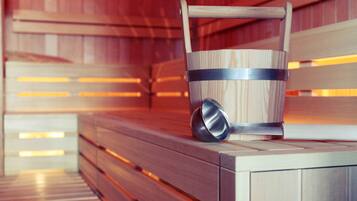 Uma sauna com bancos de madeira e um balde de metal.