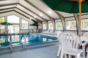 Uma área de piscina com água cristalina, espreguiçadeiras e guarda-sóis.