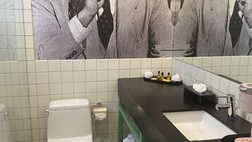 Um banheiro com vaso sanitário, pia, espelho e piso revestido de azulejos.