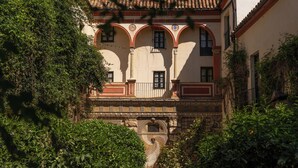 Um edifício com arcos, telhado de azulejos e fachada de pedra.