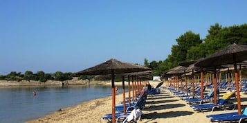 Na praia, espreguiçadeiras, guarda-sóis de praia