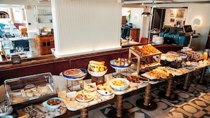 Buffet com diversos alimentos e balcão de mármore.