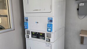 Máquina de lavar e secar empilhadas, com painéis de controle, um código QR e uma etiqueta com número de serviço.