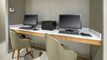 Um espaço de escritório moderno com duas mesas, cada uma equipada com computador, teclado e rato.