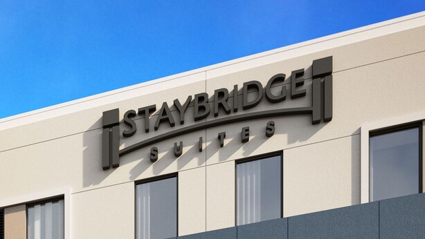 Um edifício com uma placa que diz 'STAYBRIDGE SUITES'.