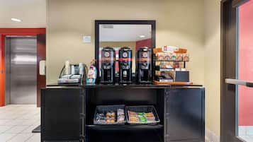 Uma estação de café com vários distribuidores, um refrigerador e recipientes para lanches.