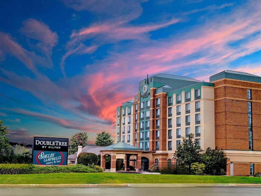 Um hotel com placa da DoubleTree by Hilton e do restaurante e bar de Shelby Campbell.