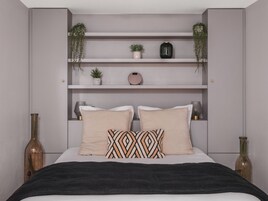 Quarto com uma cama, duas mesas de cabeceira, uma estante com plantas e objetos decorativos.