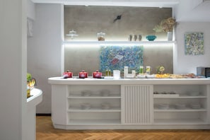 Cozinha moderna com ilha central, armários brancos e uma variedade de utensílios e acessórios de cozinha.