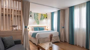 Quarto de hotel moderno com uma cama, um sofá, uma mesa de centro de madeira e uma janela grande com cortinas.