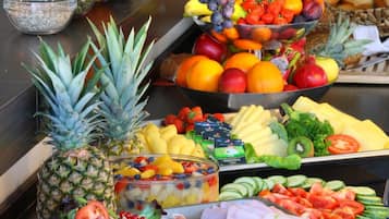 Buffet com diversas frutas, legumes e doces.