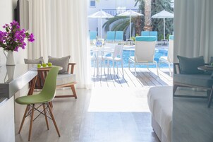 Quarto de hotel com vista para a área da piscina, incluindo espreguiçadeiras e guarda-sóis.