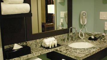 Casa de banho com lavatório, espelho, porta-toalhas e secador de cabelo.