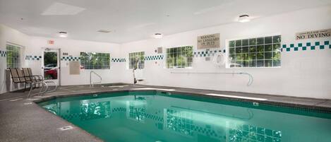 Piscina com paredes azulejadas, cadeira de salva-vidas e placa indicando que mergulhos não são permitidos.