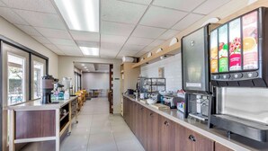 Uma cozinha moderna com cafeteira, geladeira e um painel de menu.
