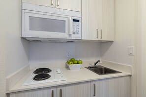 Um frigorífico/congelador grande, um micro-ondas, uma placa de cozinha 