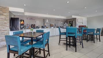 Um café moderno com cadeiras azuis, um balcão de café e um letreiro de padaria.
