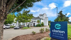 Entrada de hotel com placa da Clarion Pointe by Choice Hotels.