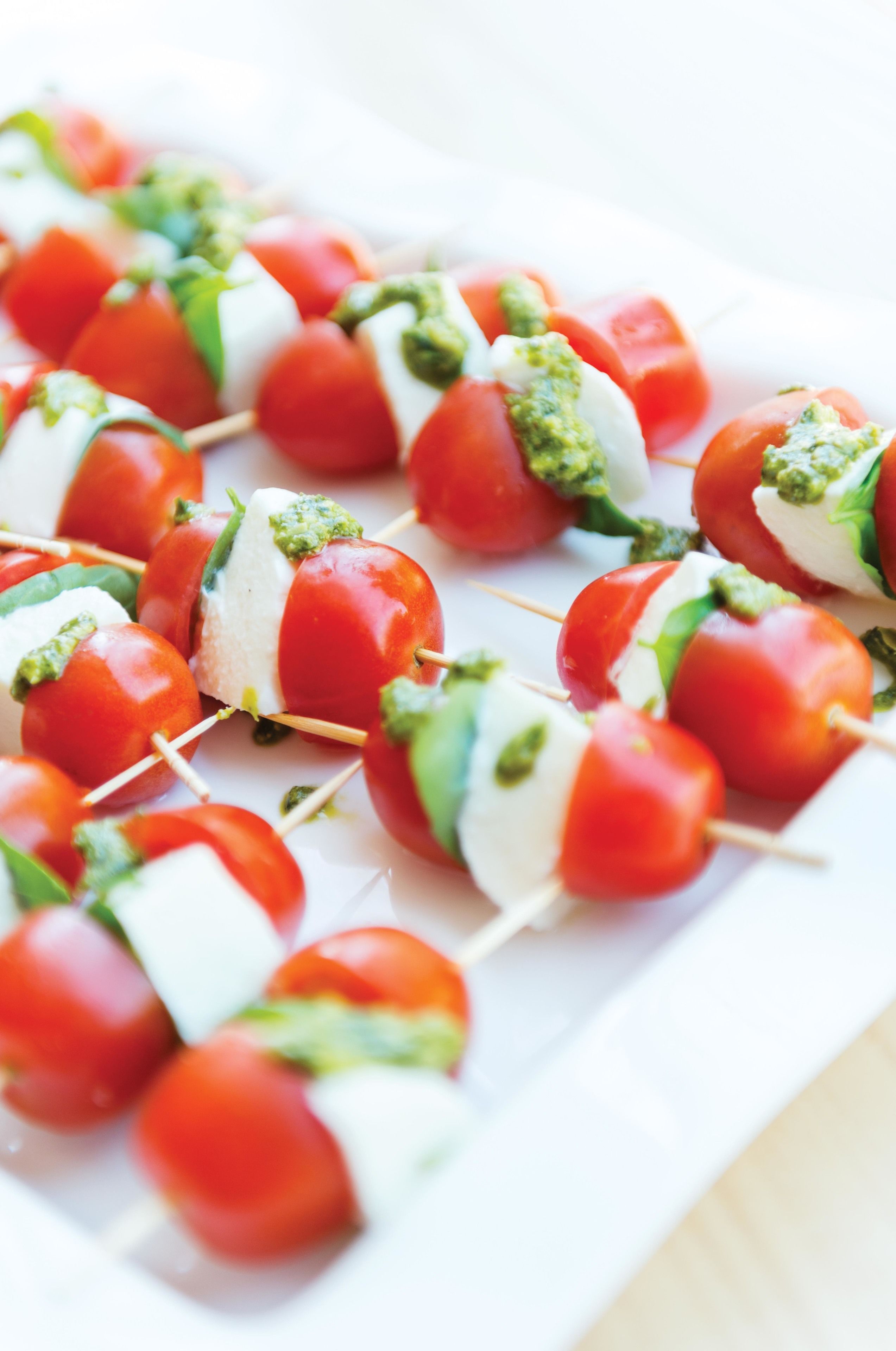 Espetinhos de mussarela e tomate com pesto.