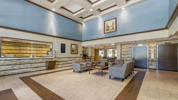 Um hall amplo com balcão de atendimento, área de estar e design de teto moderno.