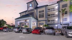 Um hotel Best Western com vários espaços de estacionamento, entrada coberta e um edifício de vários andares com varandas.