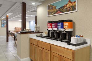 Uma estação de café com dosadores identificados para água quente, leite, café torrado escuro e café torrado claro.