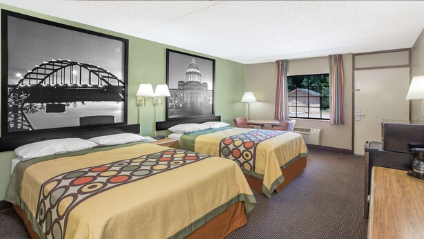 Quarto de hotel com duas camas, uma escrivaninha e uma televisão.