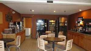 Restaurante com área de bar, mesas e máquina de café.