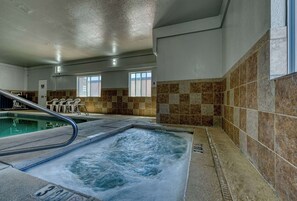 Uma área de spa com hidromassagem, piscina e um espaço de descanso com cadeiras.