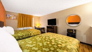 Quarto de hotel com duas camas, uma escrivaninha, televisão, espelho e micro-ondas.