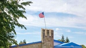 Um edifício de pedra com telhado azul e uma bandeira americana.