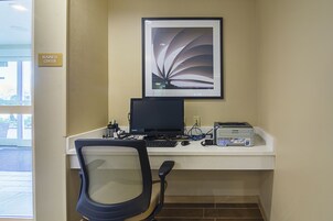 Mesa de centro de negócios com computador, impressora e cadeira.