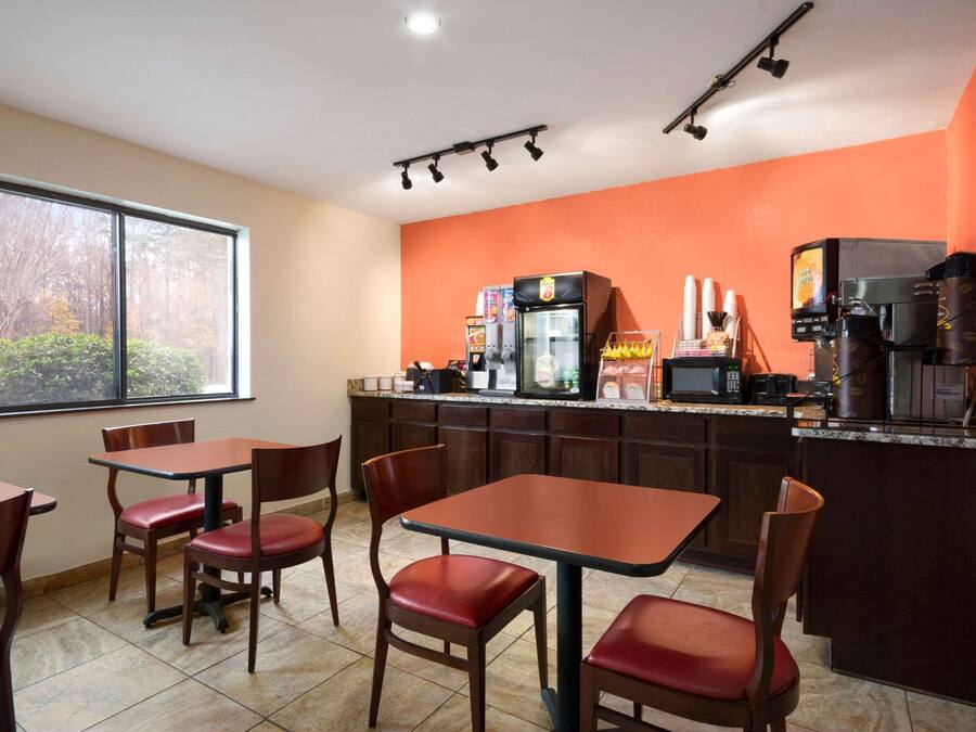 Restaurante com balcão de cozinha, área de estar e janela com vista para árvores.