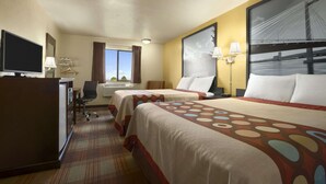Quarto de hotel com duas camas, uma escrivaninha, televisão e janela com vista para uma ponte.