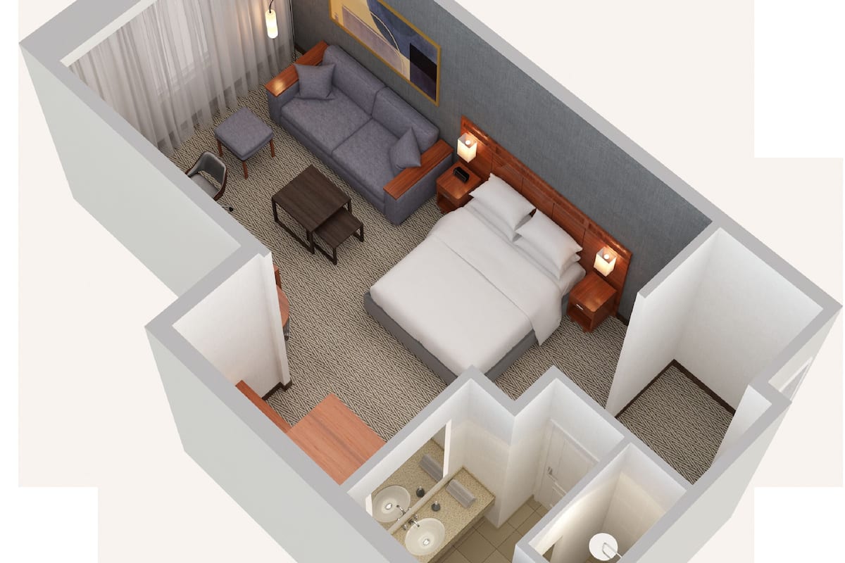 Planta baixa em 3D de um quarto de hotel, mostrando um sofá, uma cama, uma mesinha, um criado-mudo e um banheiro.