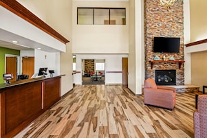 Um hall com balcão de recepção, lareira e área de estar.