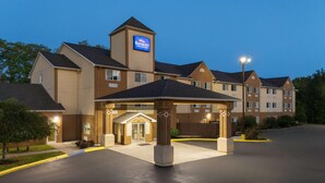 Edifício do Baymont Inn & Suites com entrada coberta, uma placa chamativa e estacionamento.