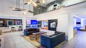 Um interior moderno com teto alto, área de bar, espaço de estar com sofás e lareira à vista.