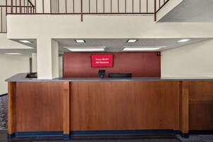 Bancada de recepção com placa indicando Wi-Fi gratuito em todos os quartos.