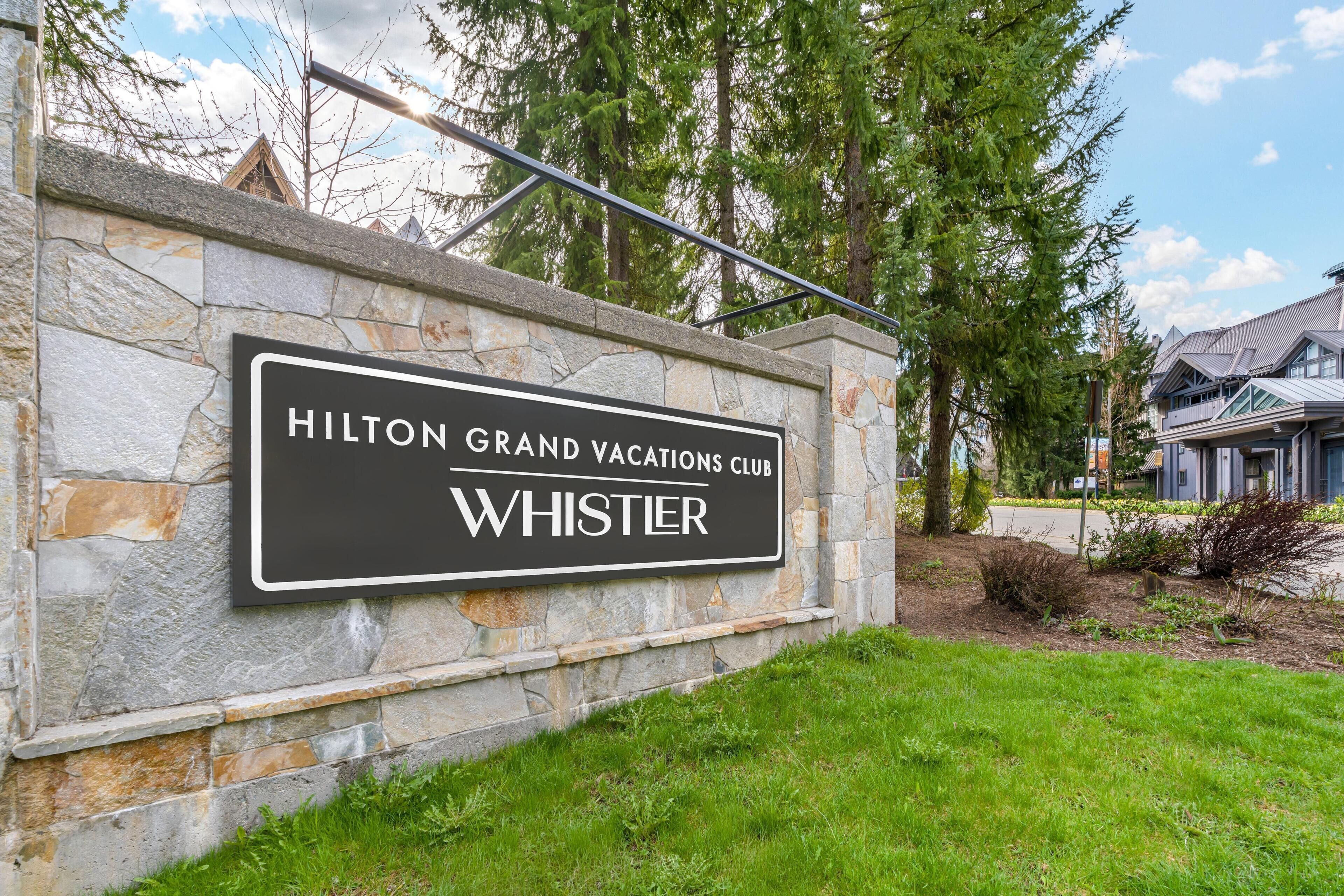 Pareda de pedra com uma placa para o Hilton Grand Vacations Club Whistler.