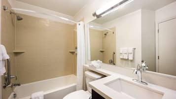 Uma casa de banho moderna com banheira, sanita e lavatório.
